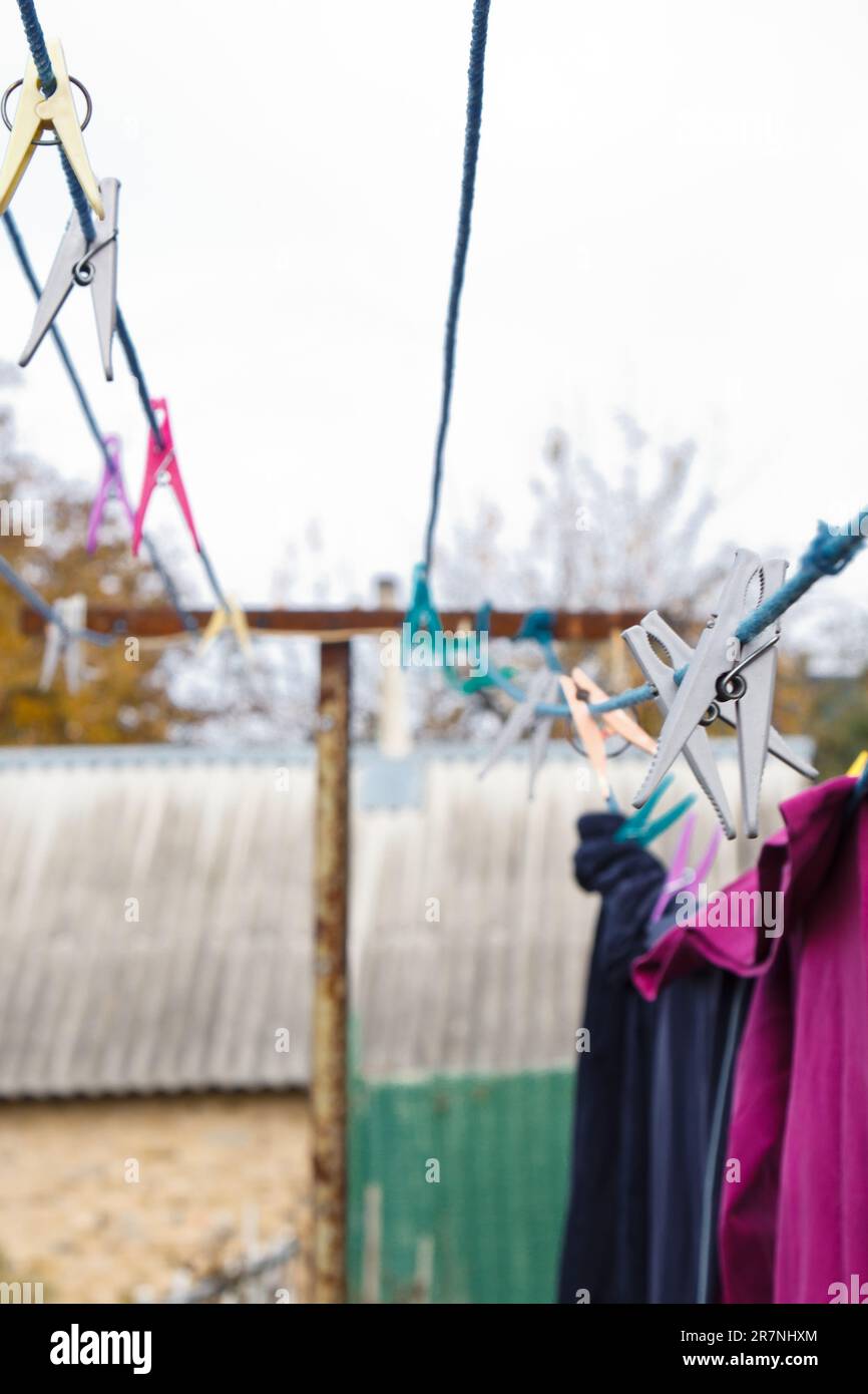 A clothespin hangs on the washing line. A rope with clean linen and ...