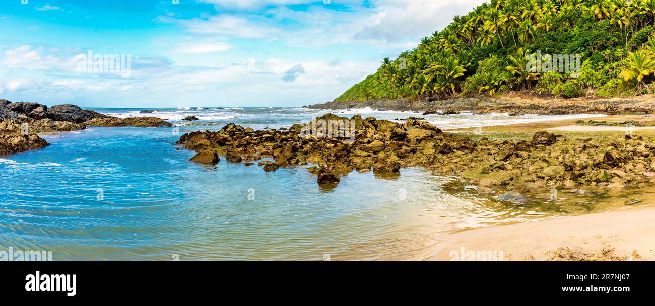 Sea between vegetation and rocks at Prainha beach in Serra Grande on ...