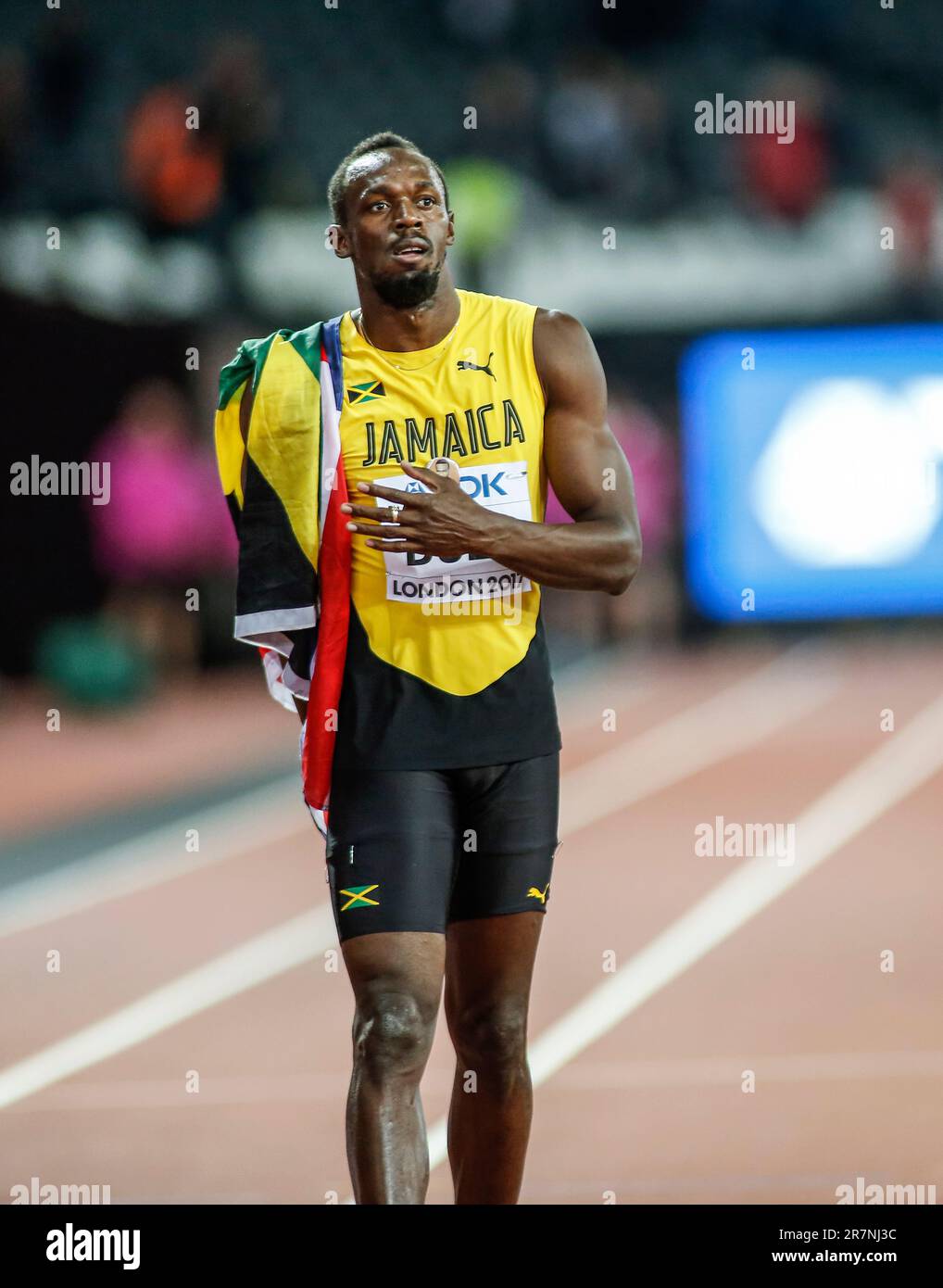 Usain Bolt on the day of his farewell, saluting and with the flag of ...