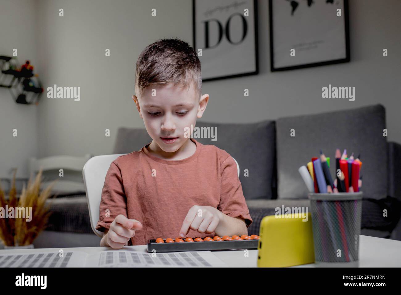 Little preschooler counting large numbers on his fingers using mental ...