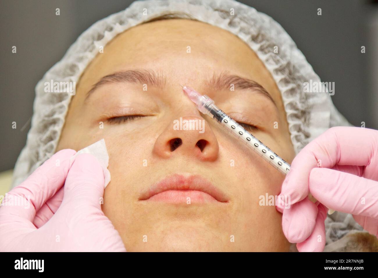 contour plastic. A cosmetologist injects a botulinum toxin to tighten ...