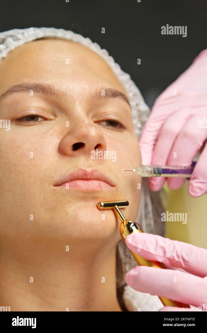 contour plastic. A cosmetologist injects a botulinum toxin to tighten ...