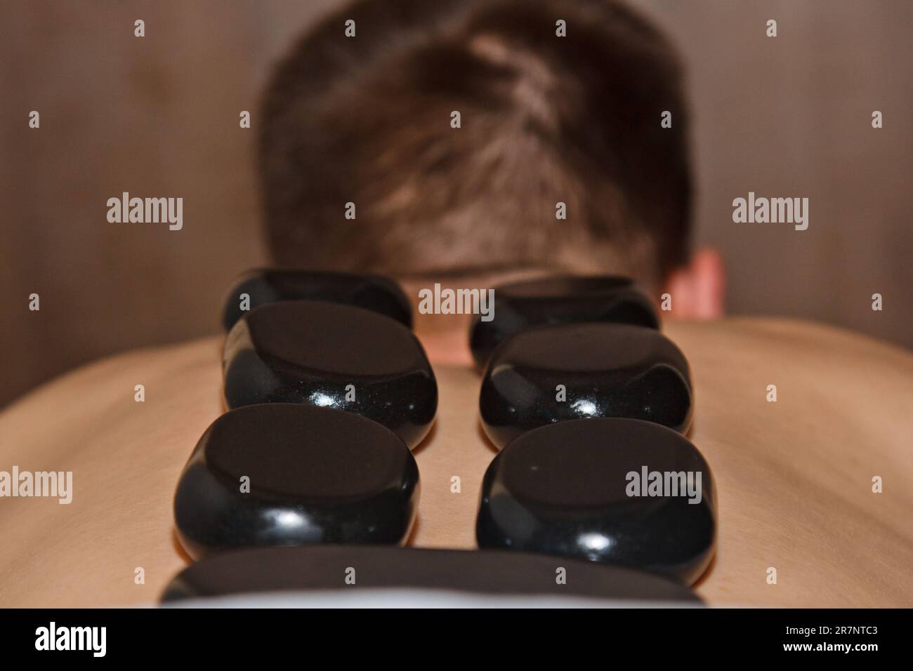 Wellness concept. Handsome young man relaxing under the stimulating ...