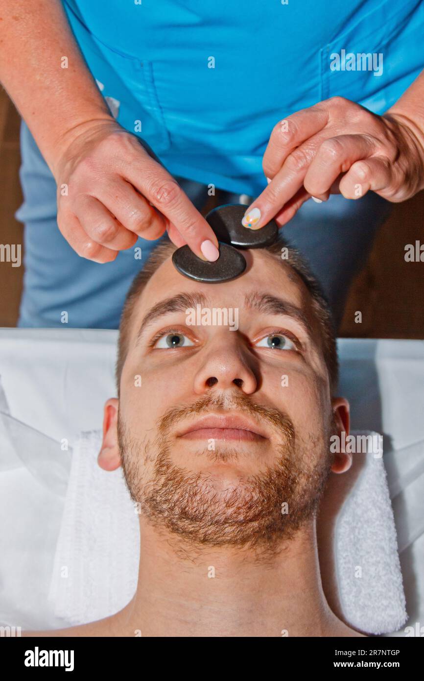 Wellness concept. Handsome young man relaxing under the stimulating ...