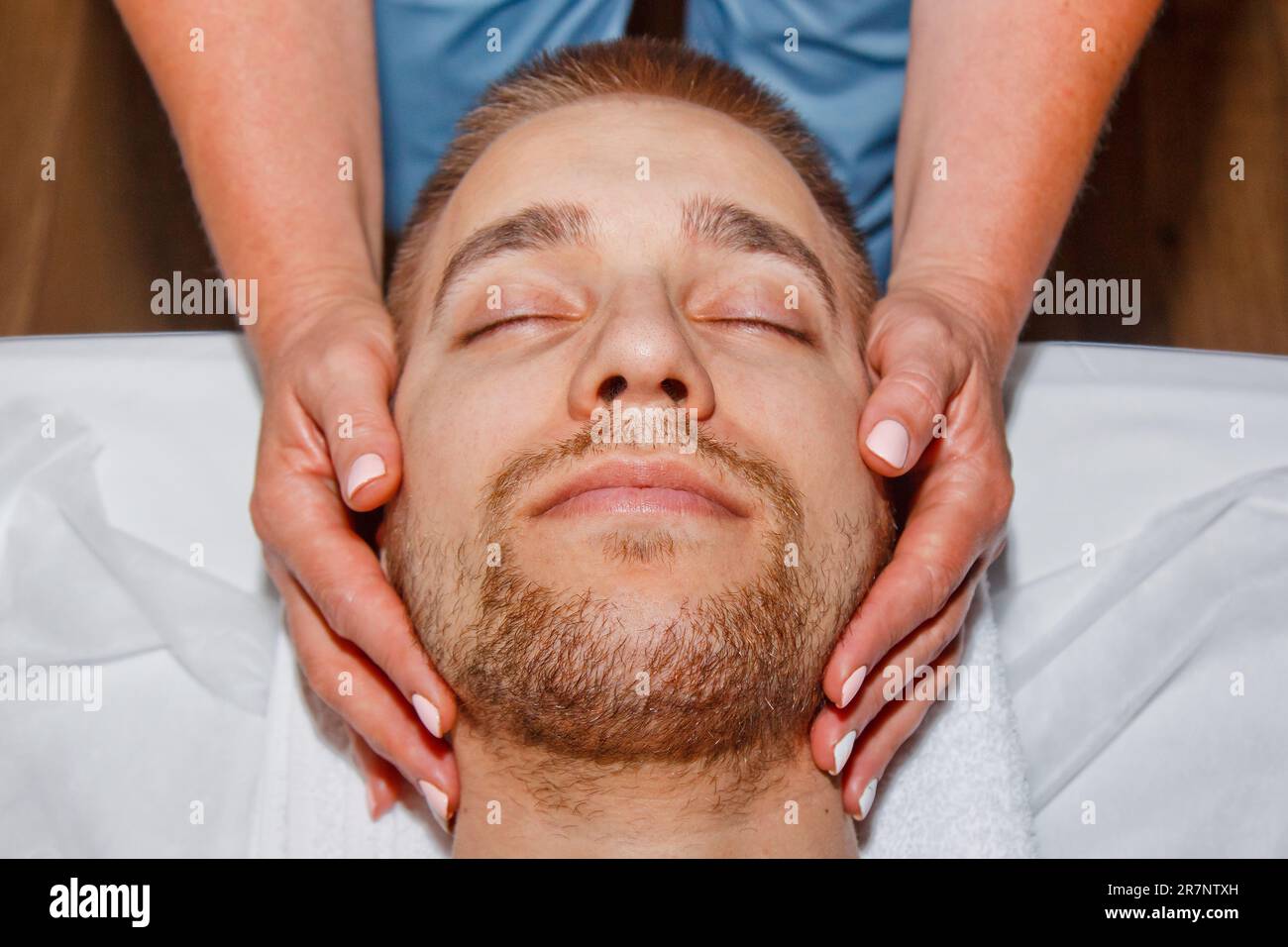 Wellness concept. Professional masseur gives a man a Thai facial ...