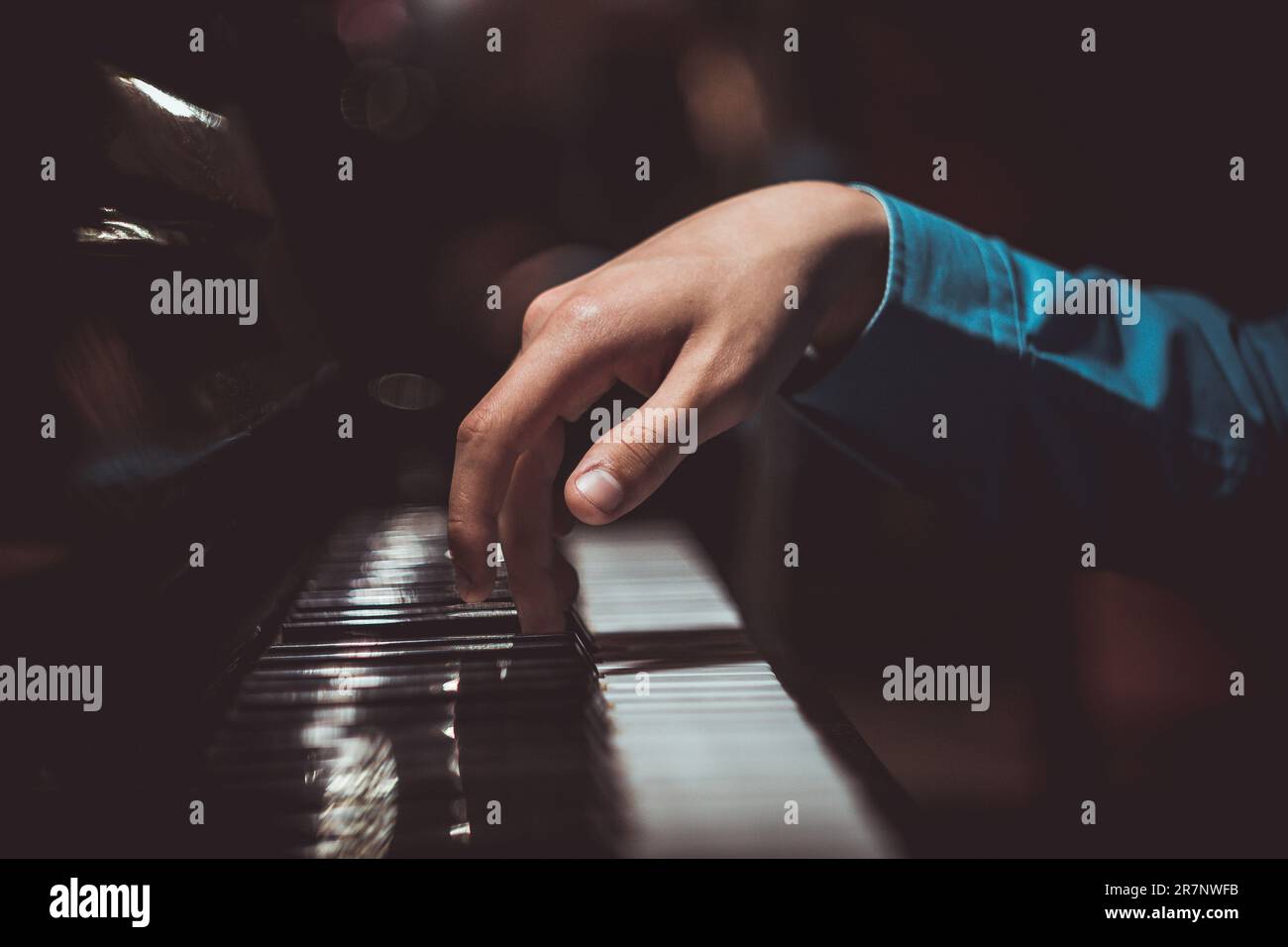 one male hand on the piano. The palm lies on the keys and plays the ...