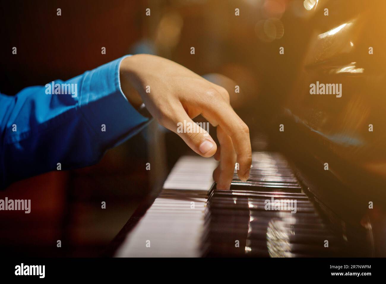 one male hand on the piano. The palm lies on the keys and plays the ...
