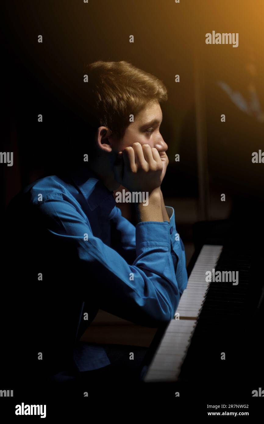 young man sitting at the piano. the boy wondered how he played the ...