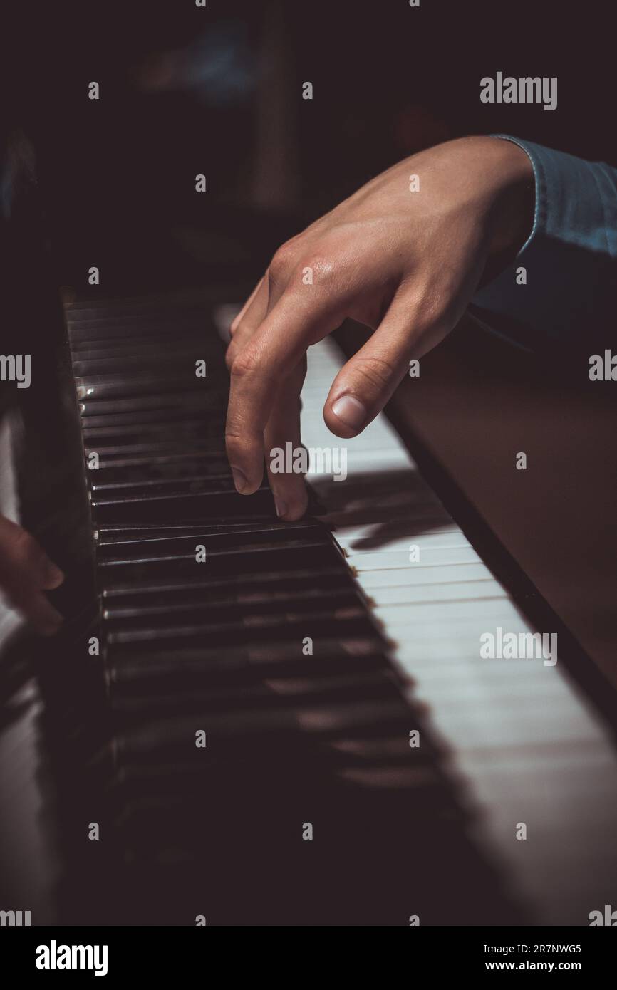 one male hand on the piano. The palm lies on the keys and plays the ...