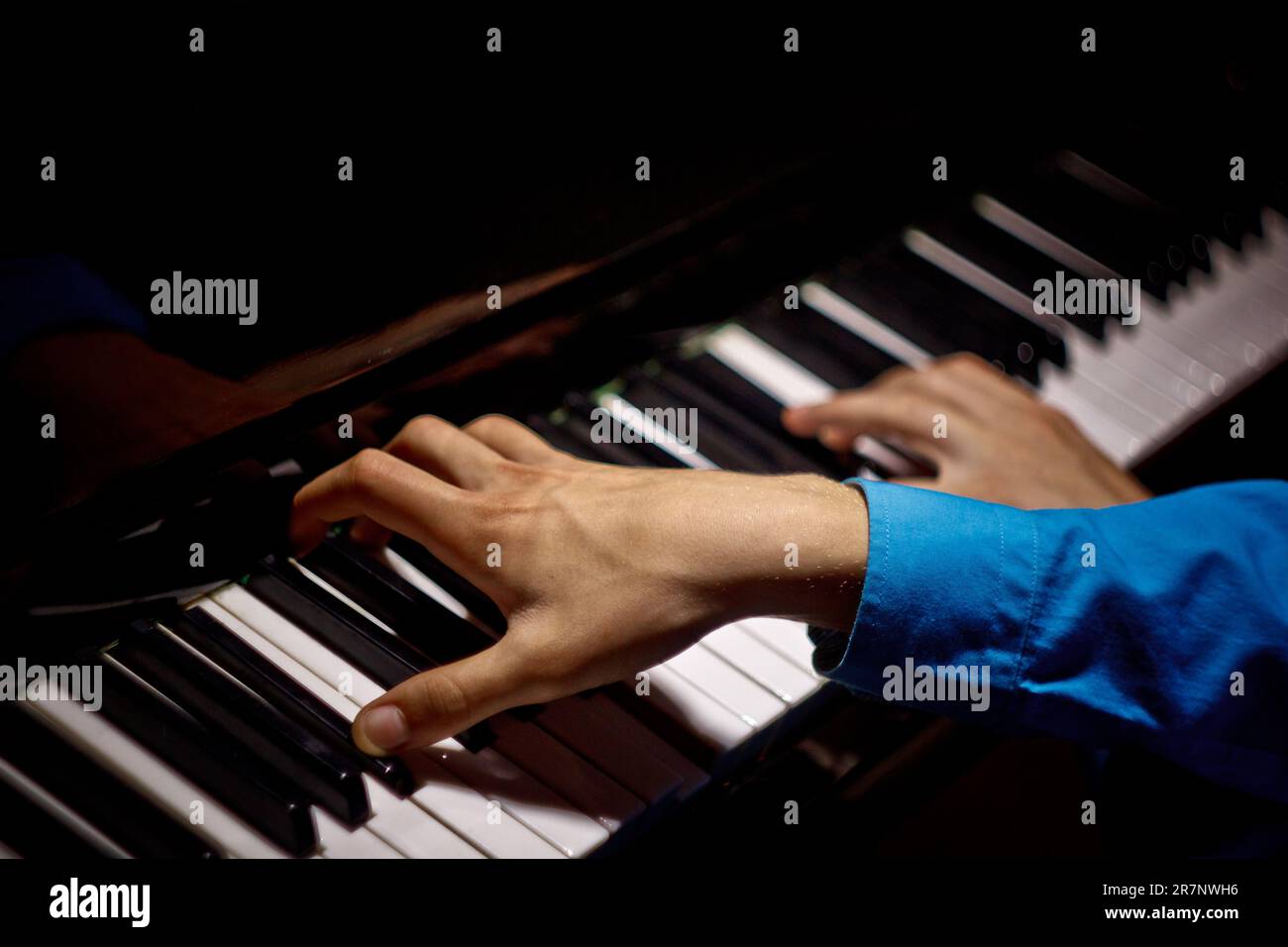 two male hands on the piano. palms lie on the keys crosswise and play ...