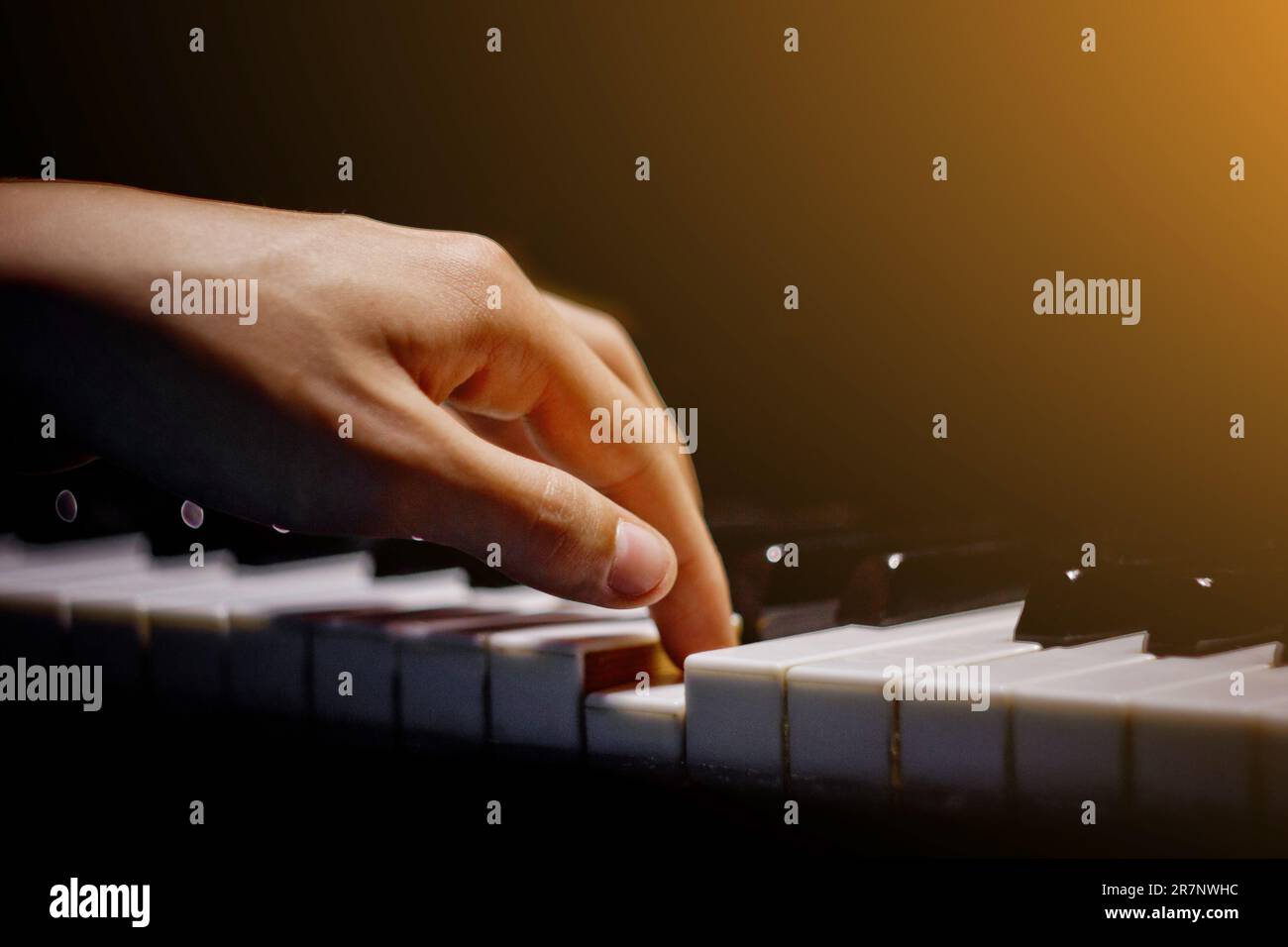 one male hand on the piano. The palm lies on the keys and plays the ...
