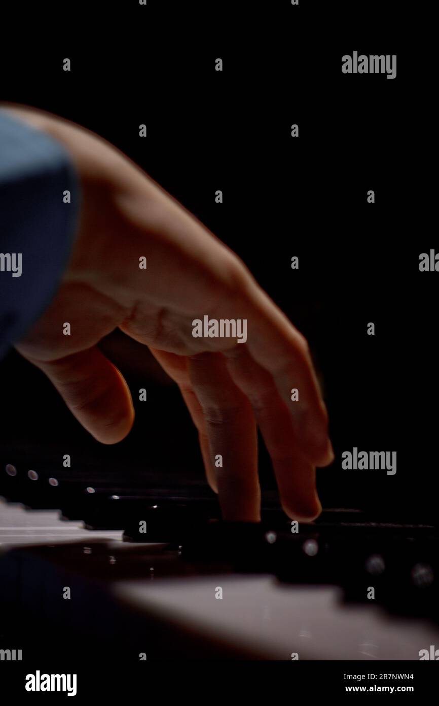 one male hand on the piano. The palm lies on the keys and plays the ...