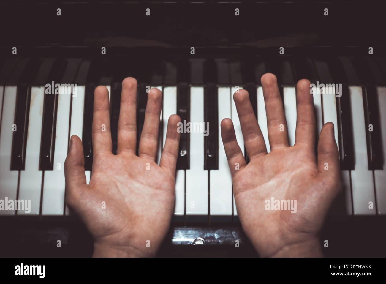 two male hands on the piano. palms lie on the keys and play the ...
