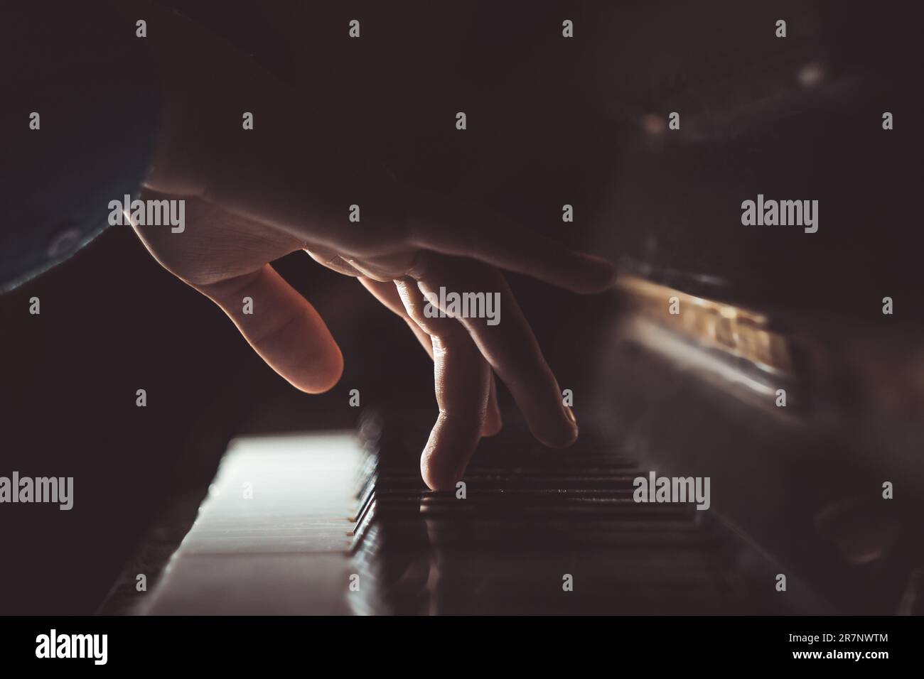 one male hand on the piano. The palm lies on the keys and plays the ...