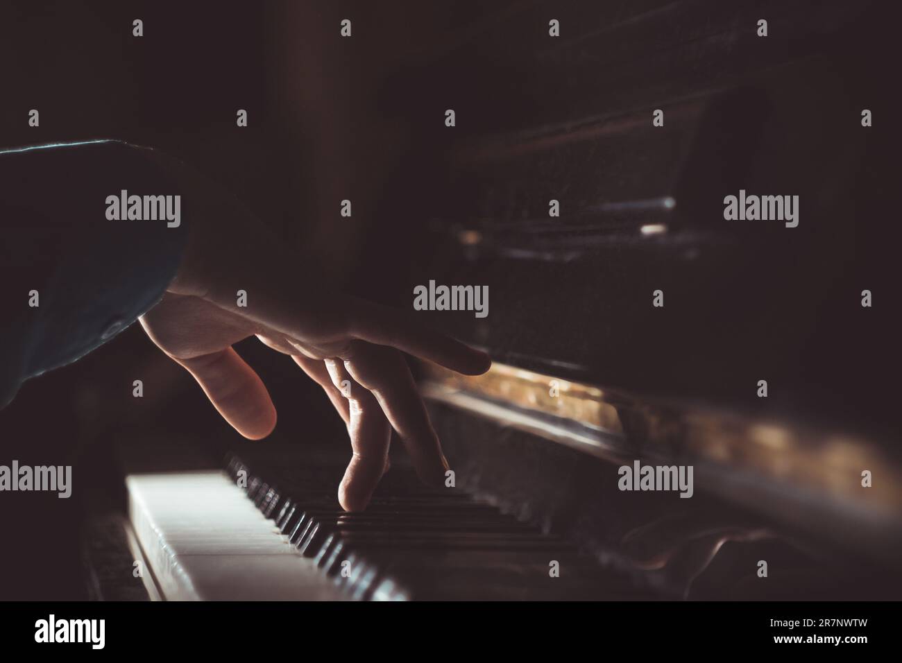 one male hand on the piano. The palm lies on the keys and plays the ...