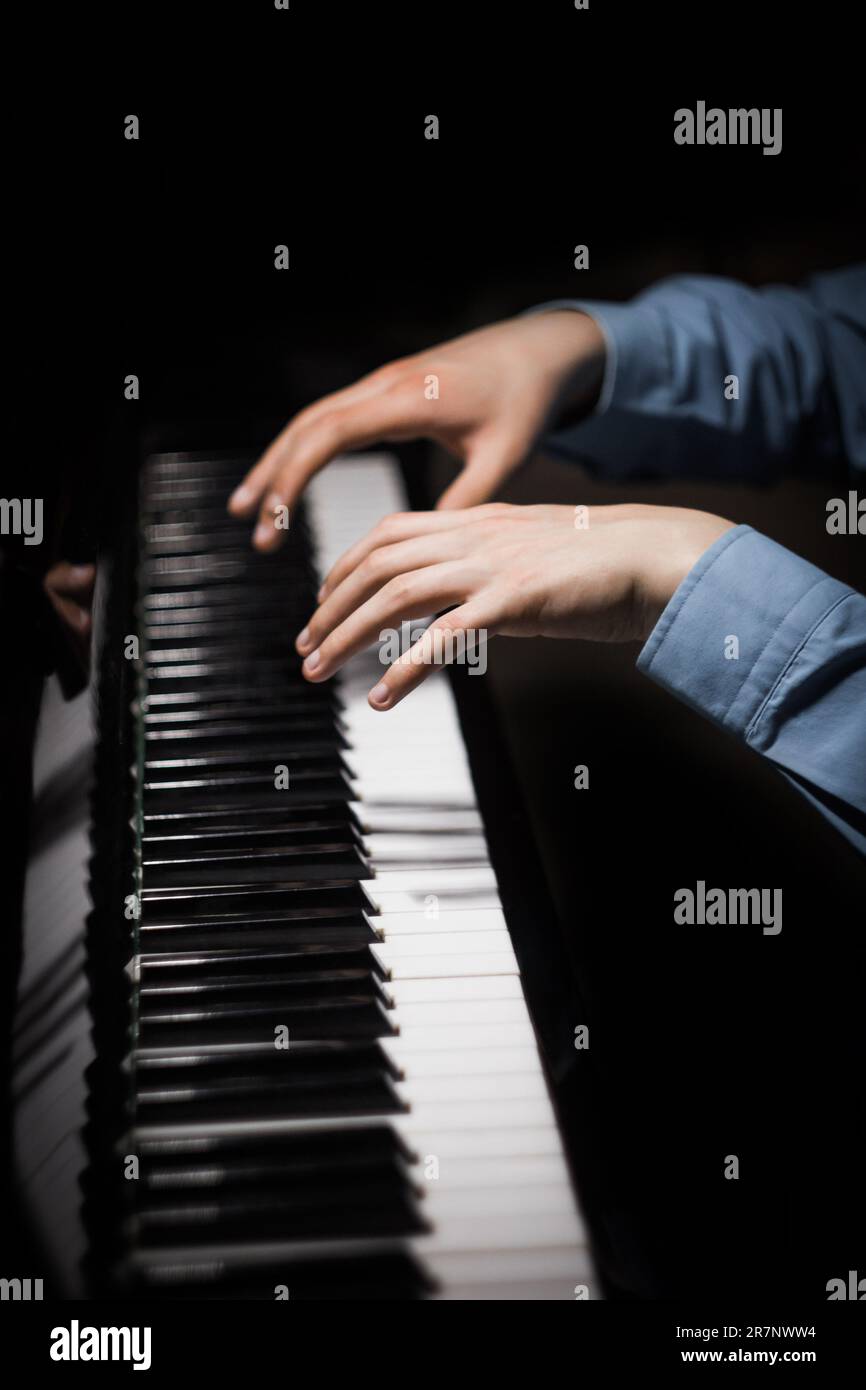 two male hands on the piano. palms lie on the keys and play the ...