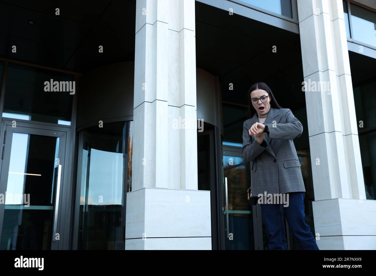Emotional woman checking time on watch outdoors. Being late concept ...