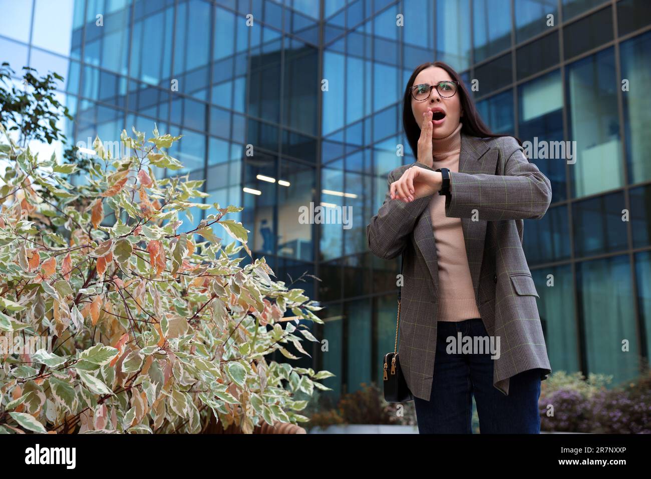 Emotional woman checking time on watch outdoors. Being late concept ...