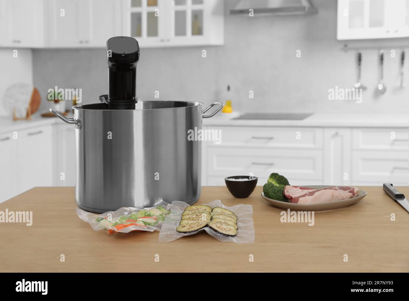 Pot with sous vide cooker, vacuum packed vegetables and ingredients on ...