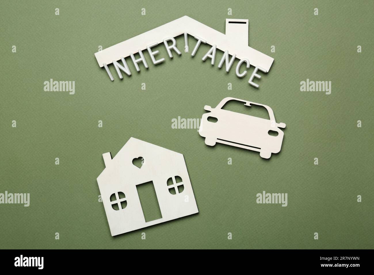 Word Inheritance, car and house models on green background, flat lay ...