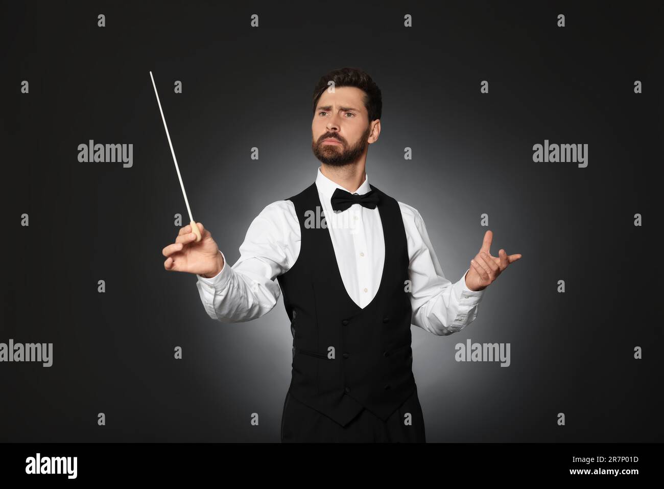 Professional conductor with baton on black background Stock Photo - Alamy