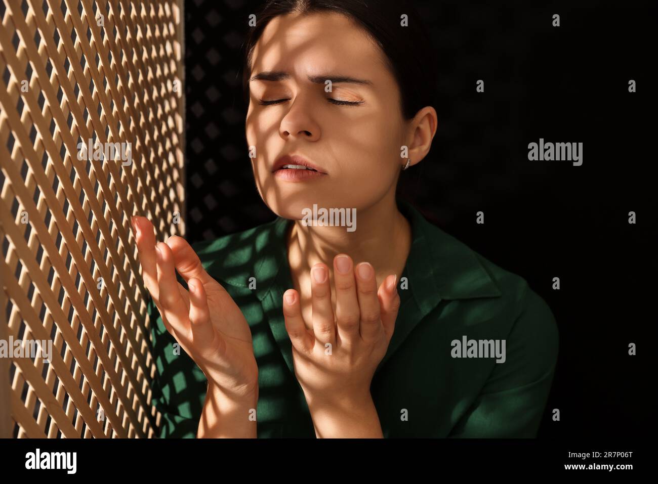 Woman praying to God during confession in booth Stock Photo - Alamy