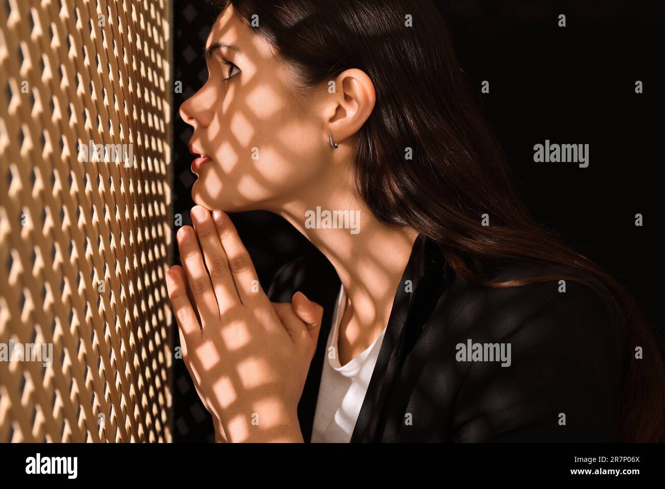 Woman praying to God during confession in booth Stock Photo - Alamy