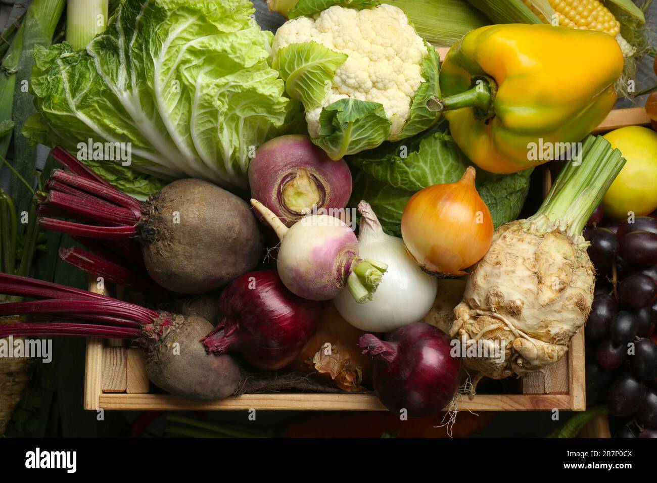 Different fresh vegetables in wooden crate as background, top view ...
