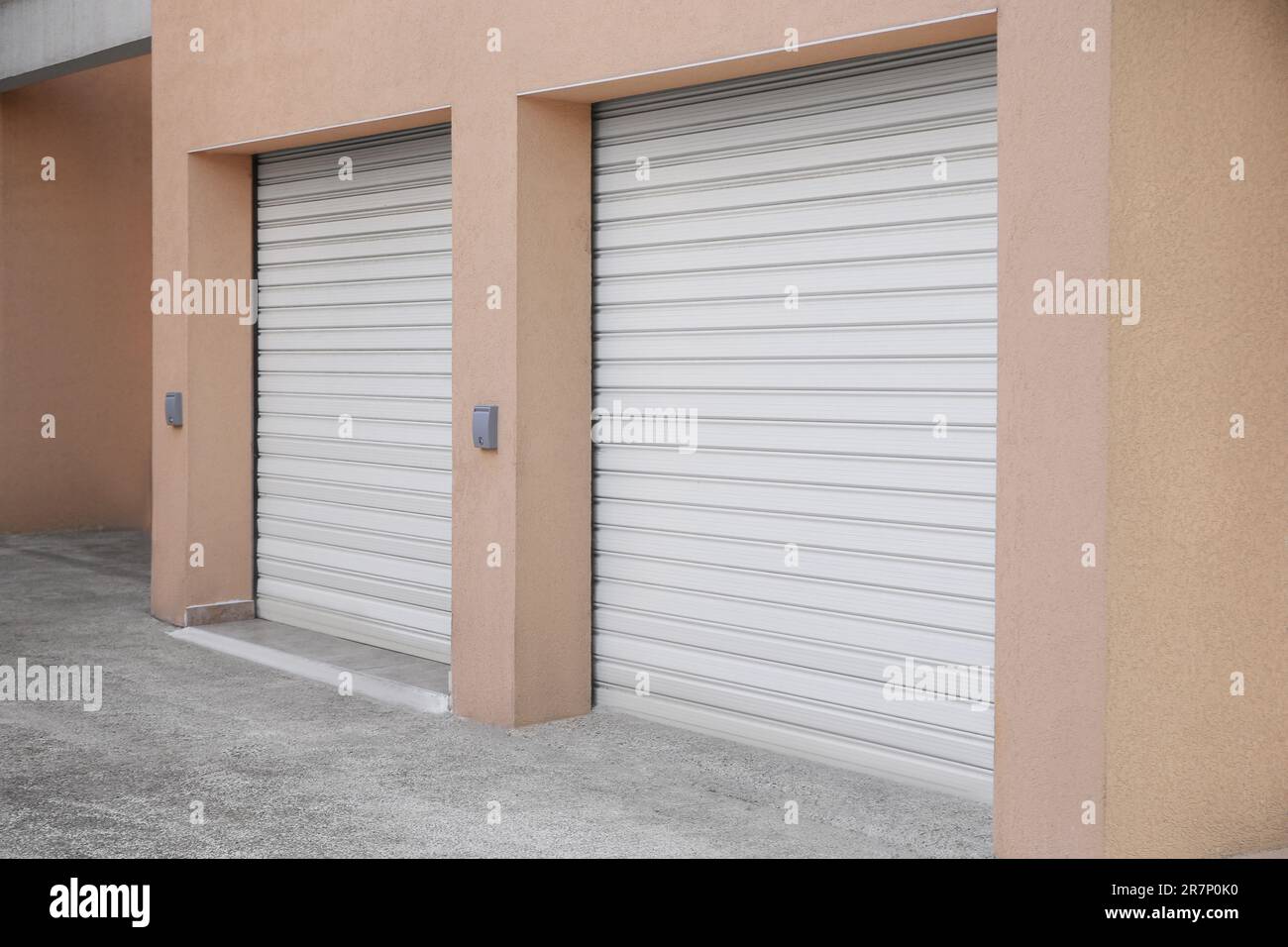 Building with white roller shutter garage doors Stock Photo - Alamy
