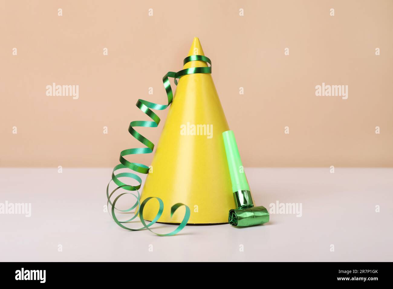 Colorful party hat, streamer and blower on white table. Birthday ...