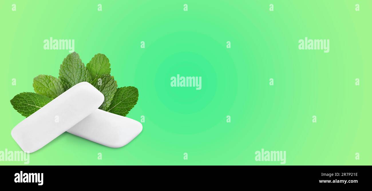 Menthol chewing gum pillows and mint leaves on green gradient ...