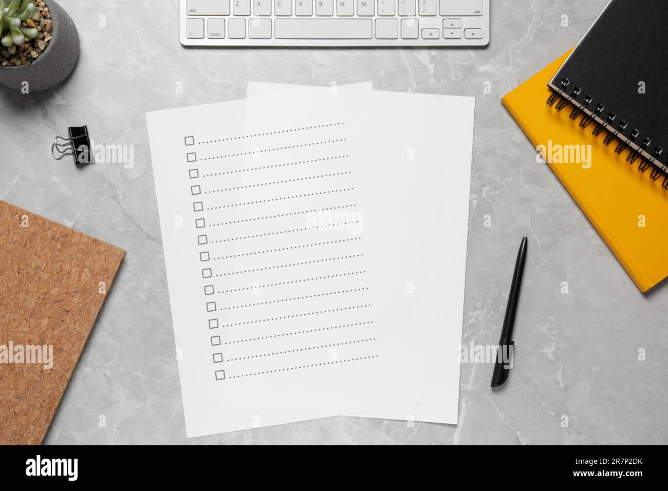 Paper sheet with checkboxes plant and computer keyboard on light grey ...