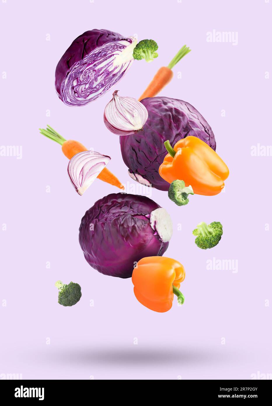 Many different fresh vegetables falling on pale light violet background ...