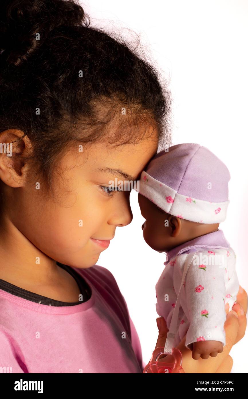 Young girl holding doll to forehead Stock Photo - Alamy Young girl holding doll to forehead Stock Photo - Alamy