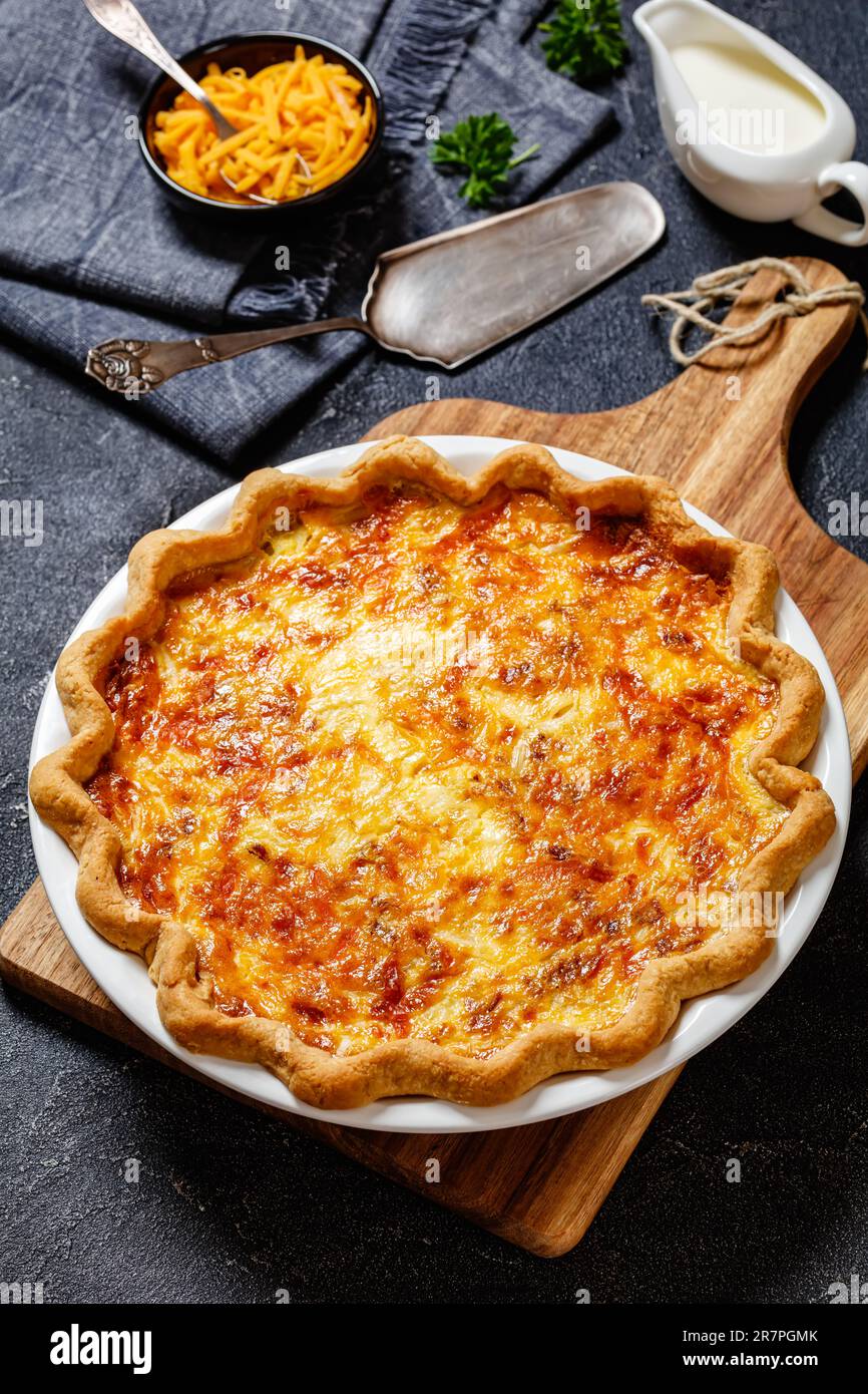 fluffy breakfast quiche with cheese and bacon in baking dish on dark ...