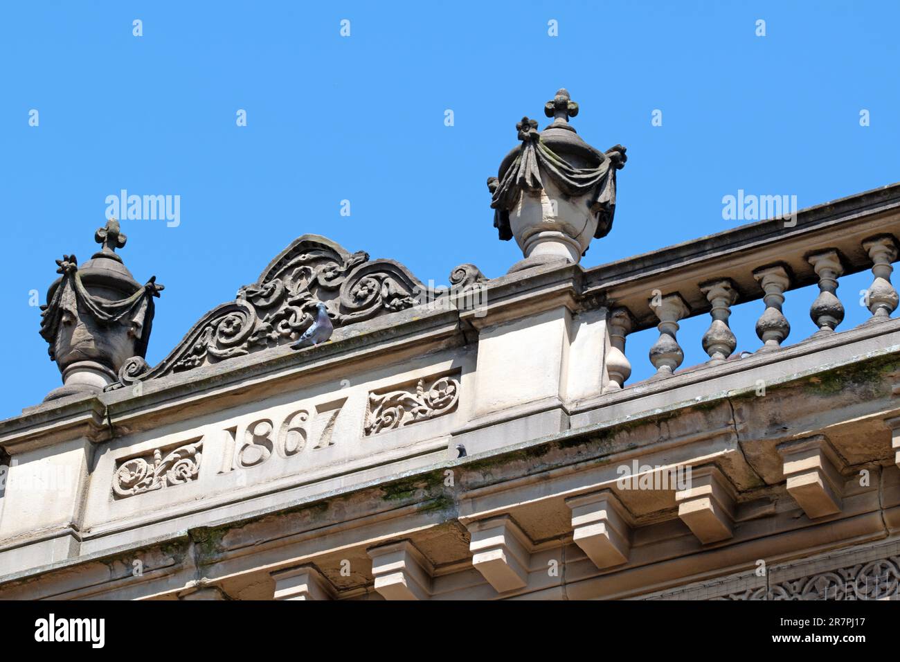 Sandstone carved urns on building roof parapet, dated 1867 Stock Photo ...
