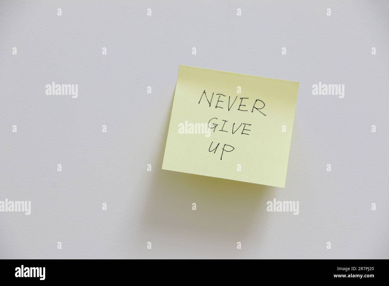 Yellow sticky note on wall with motivational and inspirational message ...