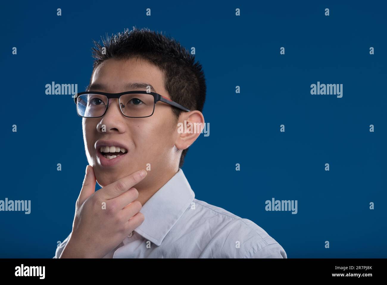 Asian man on a blue background has an idea to solve a problem. His ...