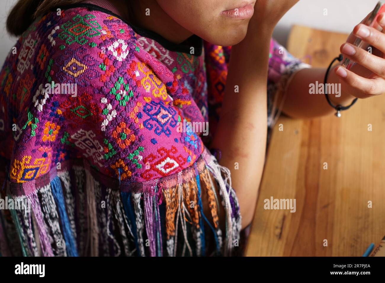 Guatemalan mayan girl putting on makeup in traditional huipil dress ...