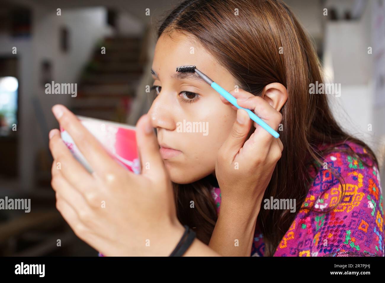 Guatemalan mayan girl putting on makeup in traditional huipil dress ...
