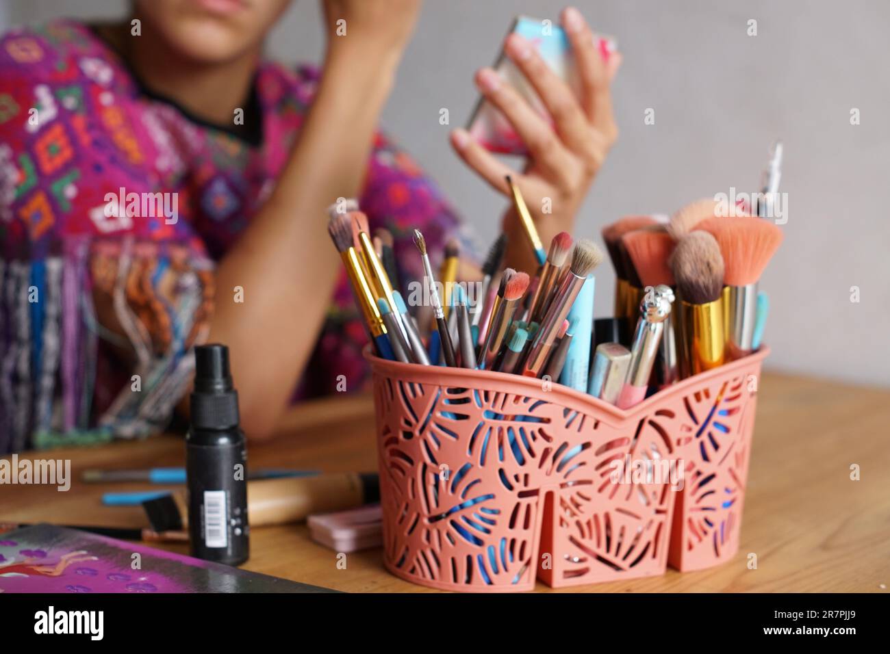 Guatemalan mayan girl putting on makeup in traditional huipil dress ...
