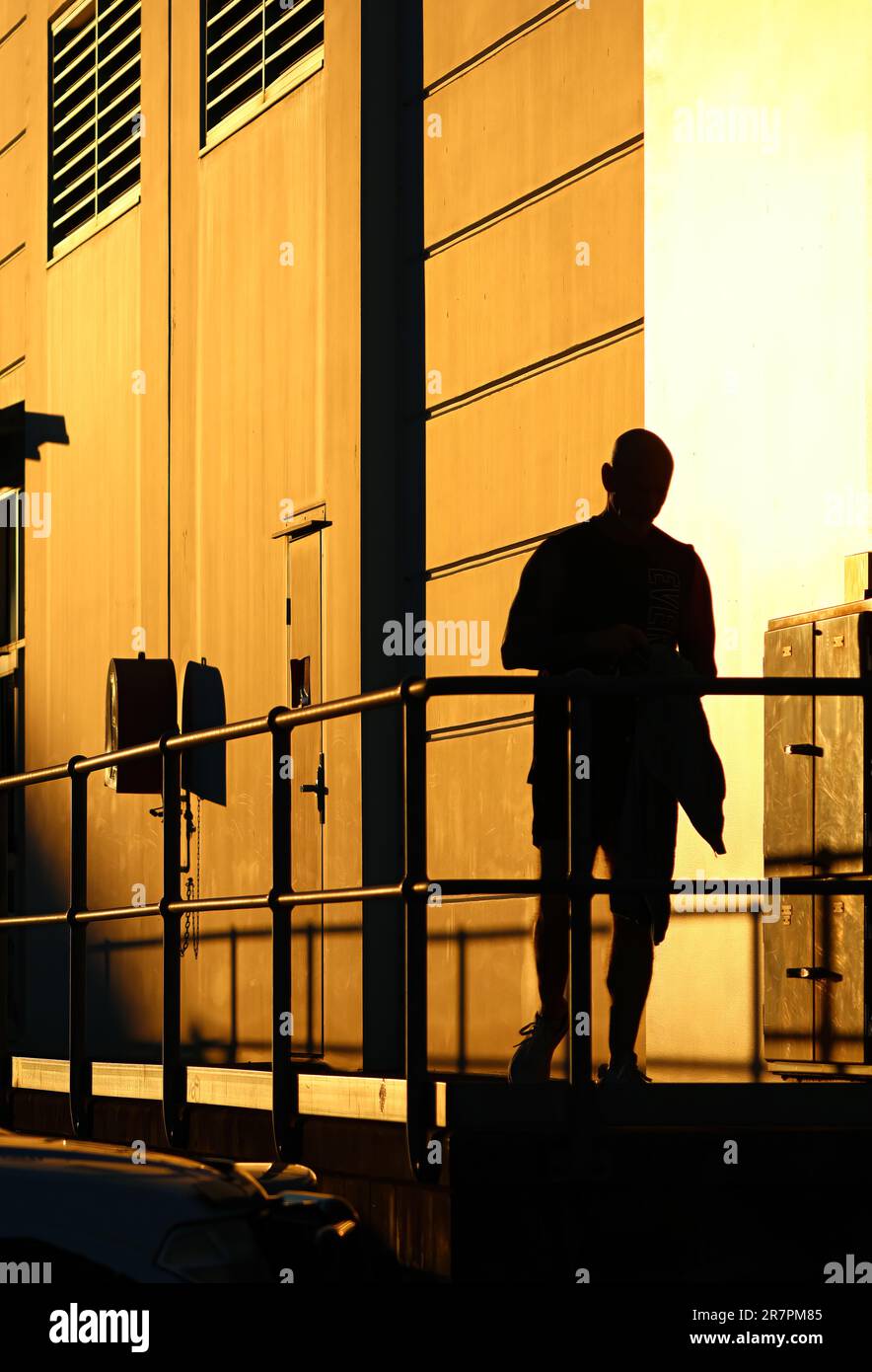 Random street photography, of a person's silhouette walking along at ...