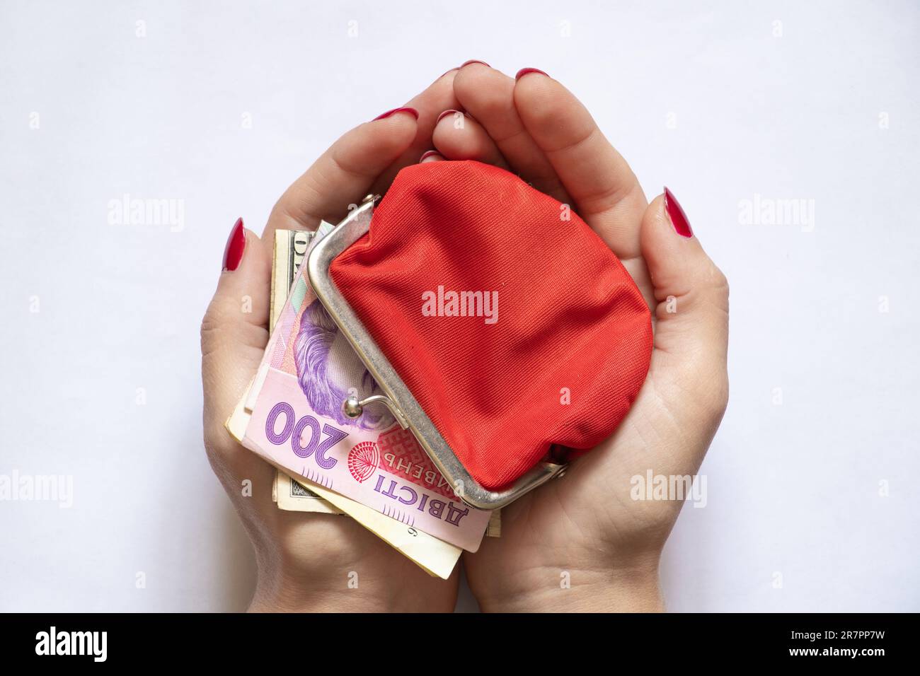 200 UAH in a red wallet and a woman's hand on an isolated background ...