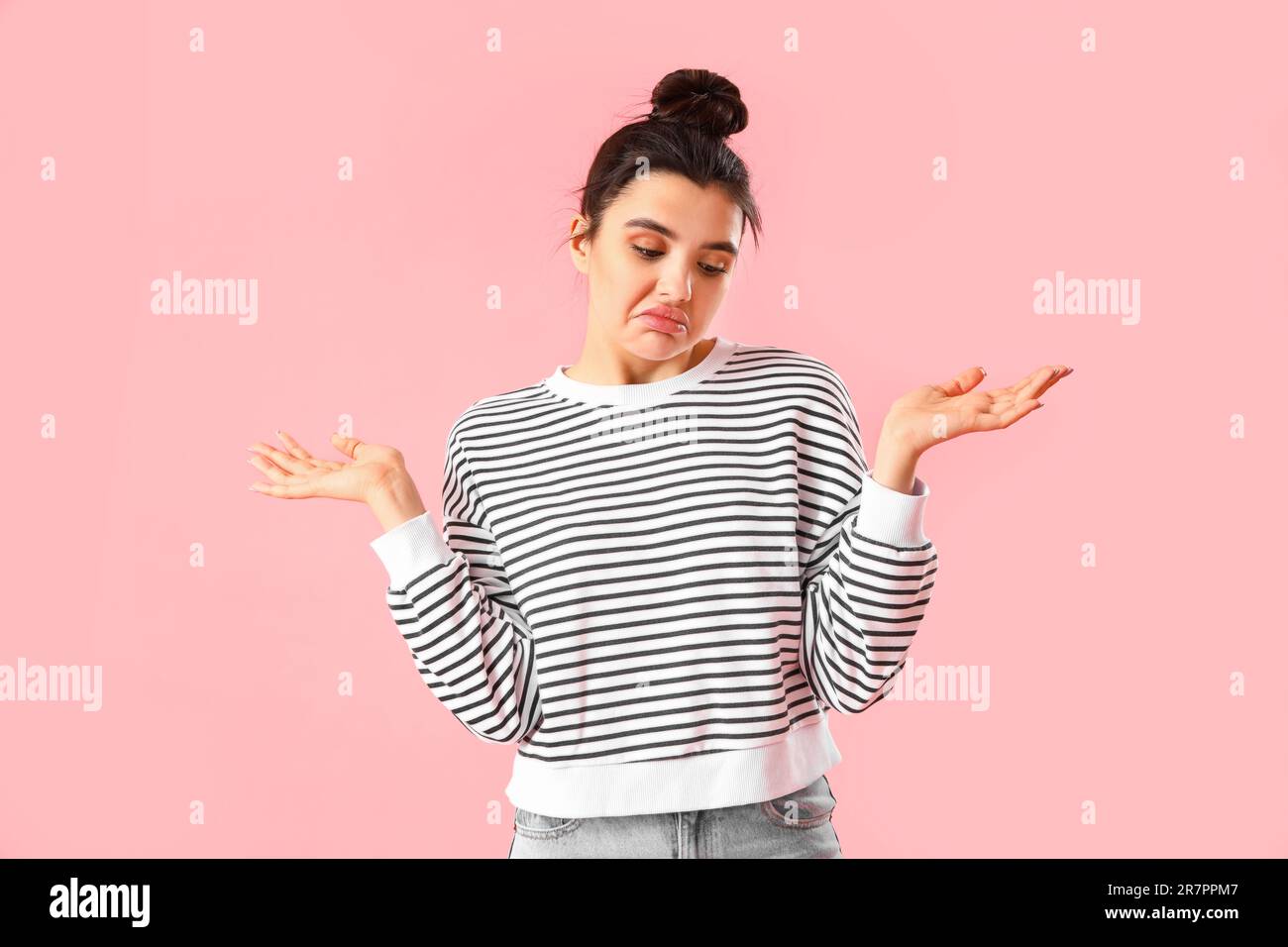 Confused young woman on pink background Stock Photo - Alamy
