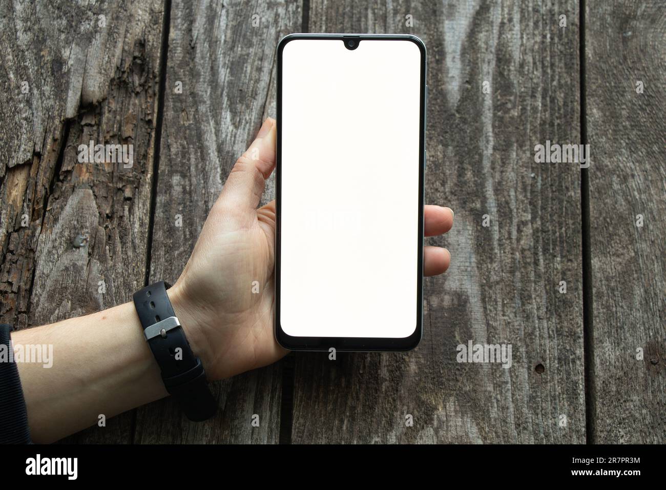 phone in the hands of a young girl with a white screen for design close ...