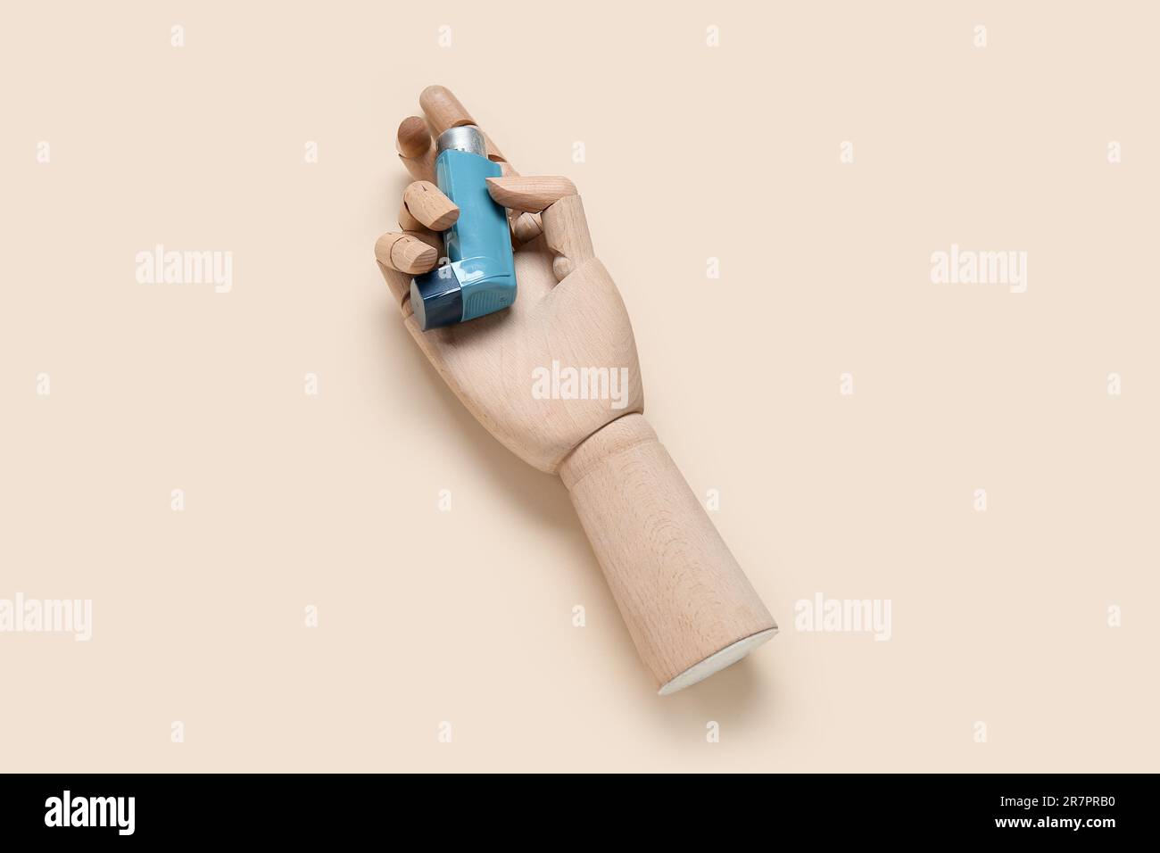 Wooden hand with asthma inhaler on beige background Stock Photo - Alamy