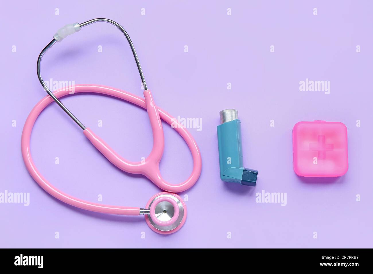 Composition with asthma inhaler, stethoscope and box of pills on lilac ...