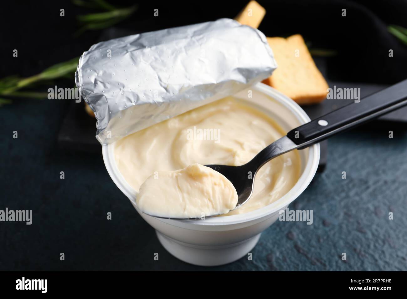 Plastic container with tasty cream cheese on black background Stock ...