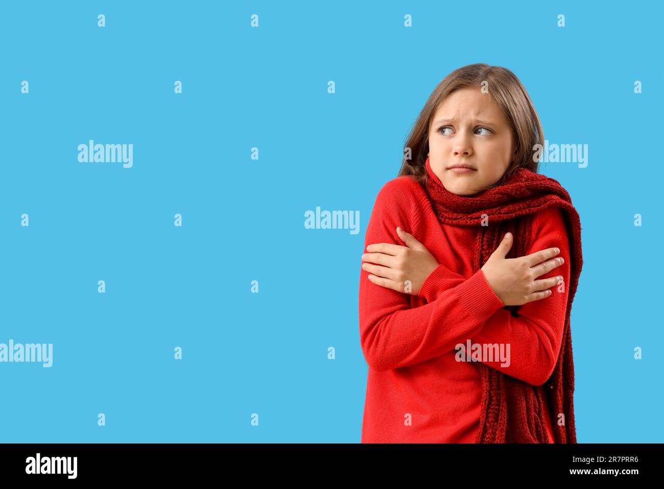 Ill little girl freezing on blue background Stock Photo - Alamy