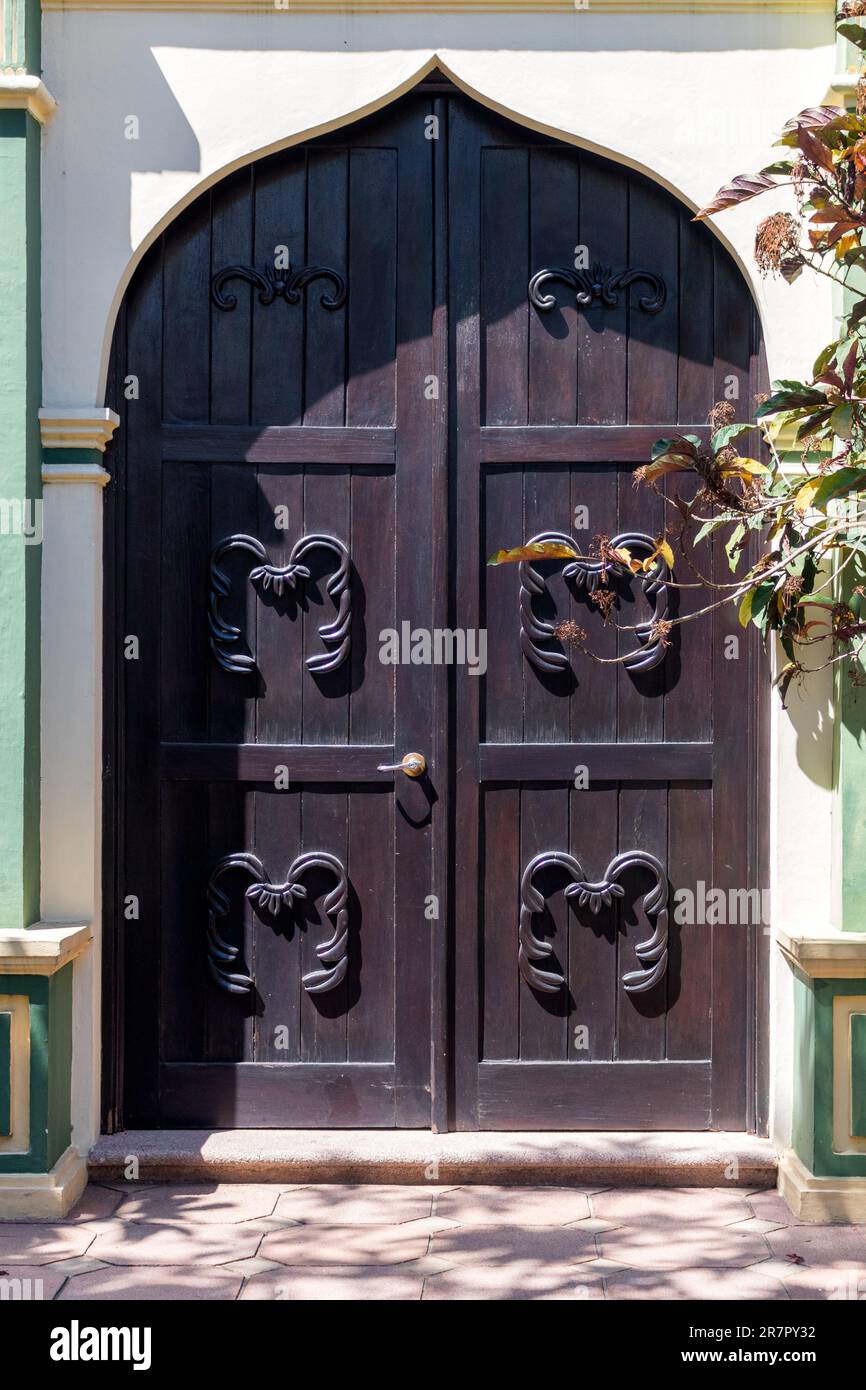 A vertical of a wooden door with intricate patterns in sunlight Stock ...